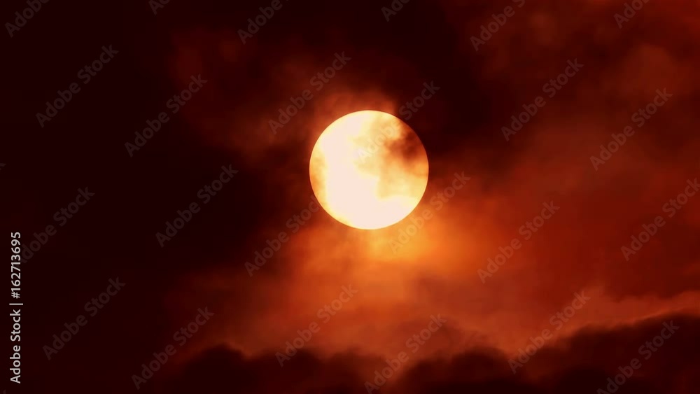 Big sun disk in sunset in cloudy sky timelapse. horror and terror ...
