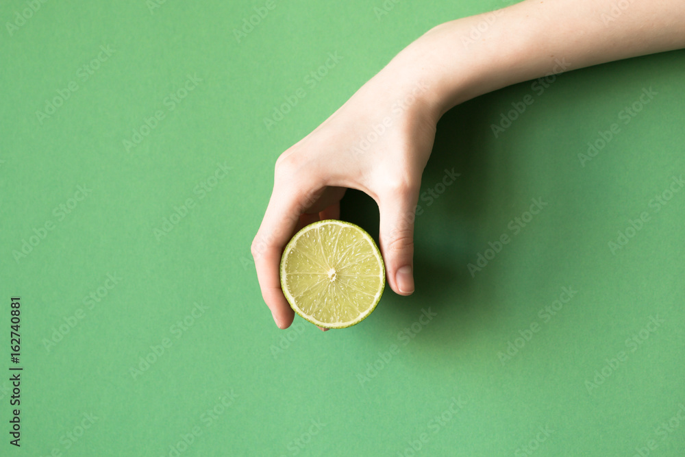 Fresh juicy tasty green lime in a human hand on green background Stock ...