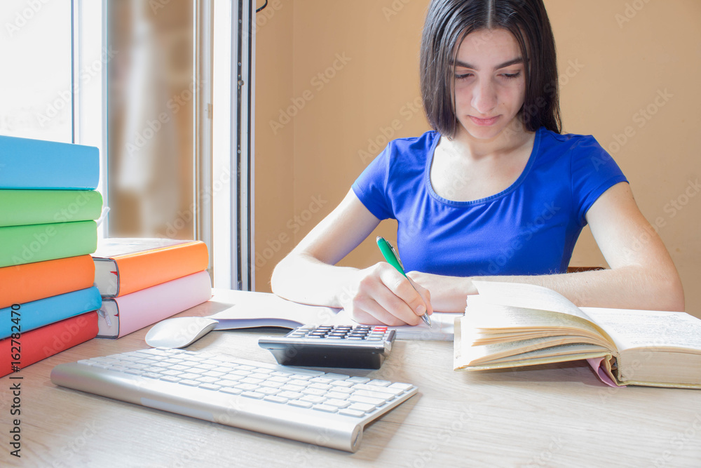 Girl studying. Girl doing her homework. School books on desk, education ...