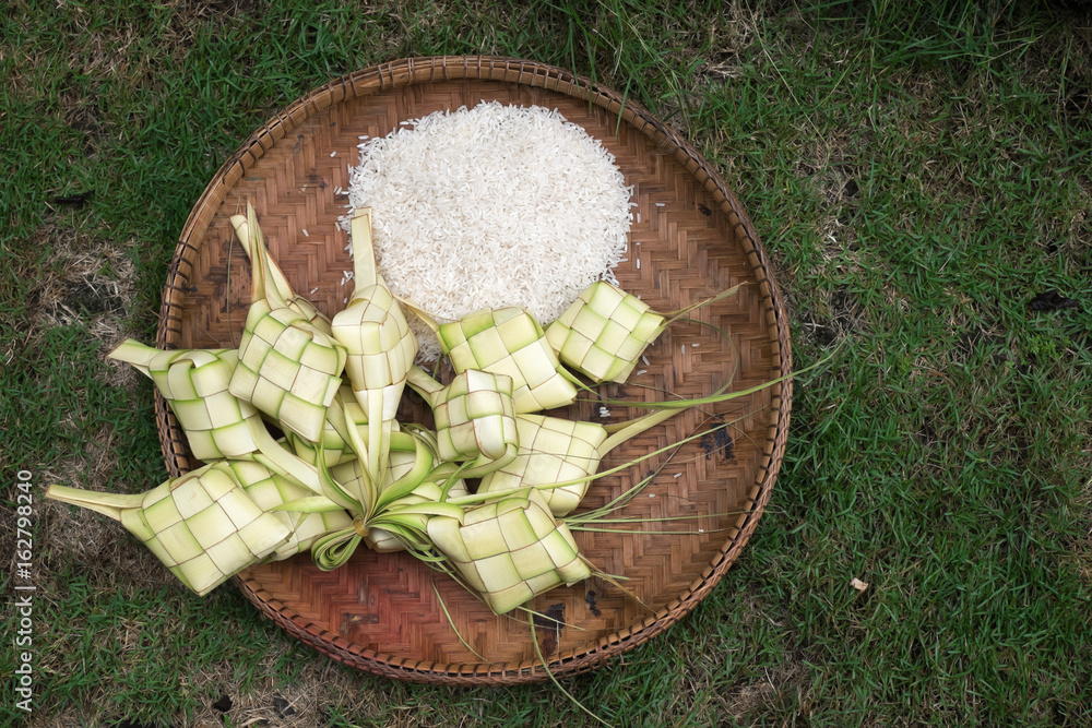 Ketupat in the bamboo basket. Made of rice wrapped in coconut leaves ...