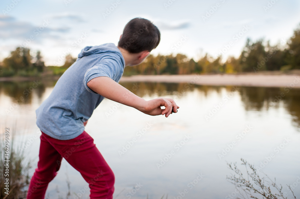 boy skimming stones Stock Photo | Adobe Stock