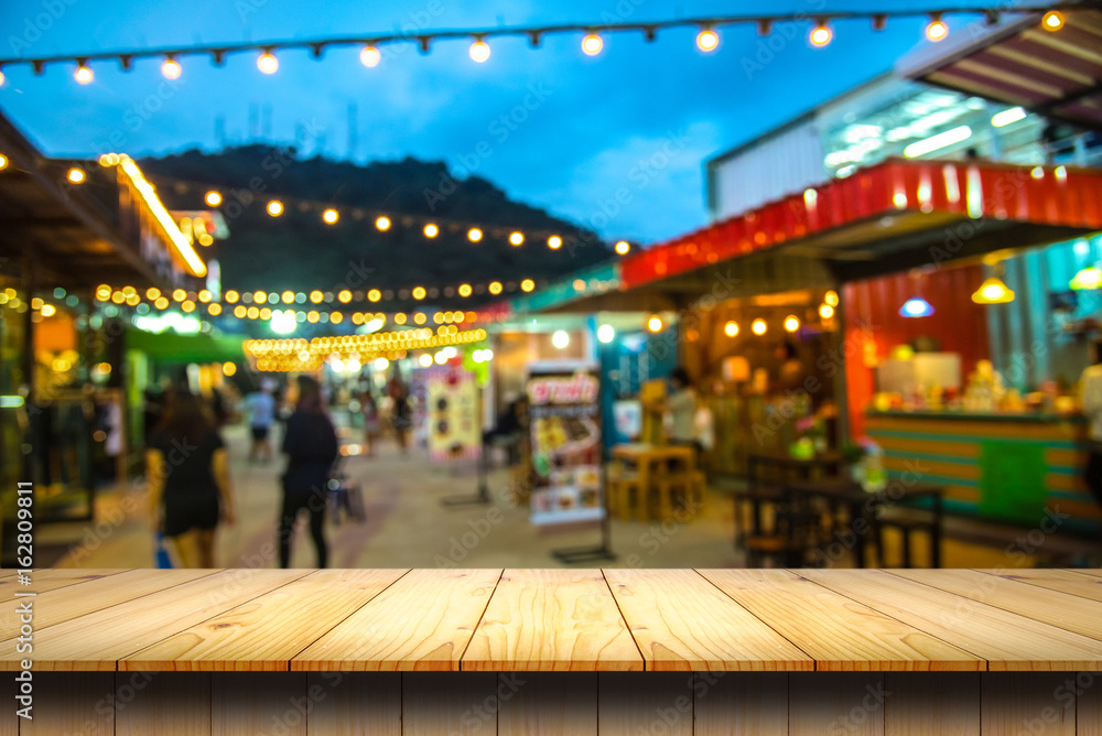 empty wooden table and blurred image of night market for product ...