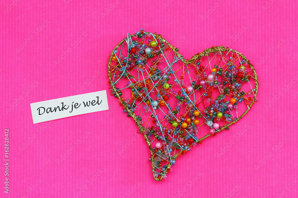 Dank je wel (thank you in Dutch) card with heart on vivid pink surface ...