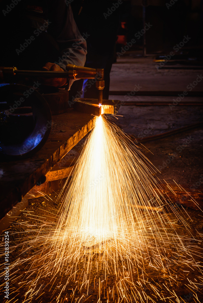 Worker cutting steel plate with acetylene welding cutting torch and ...