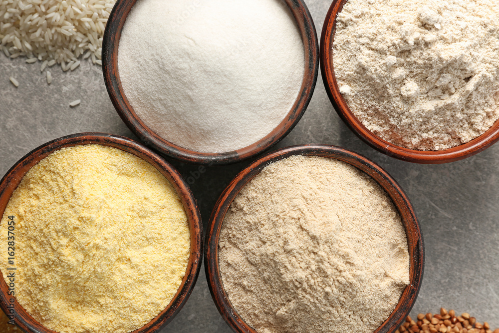 Bowls with different types of flour on gray background Stock Photo ...