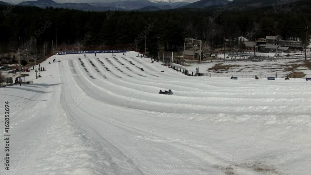 Looking down from top of snow tubing trails as tubers make their way ...