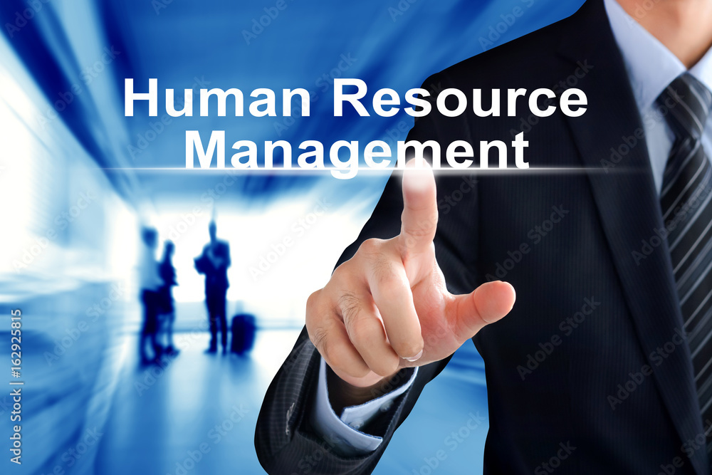 Businessman hand touching HUMAN RESOURCES MANAGEMENT (or HRM) sign on ...