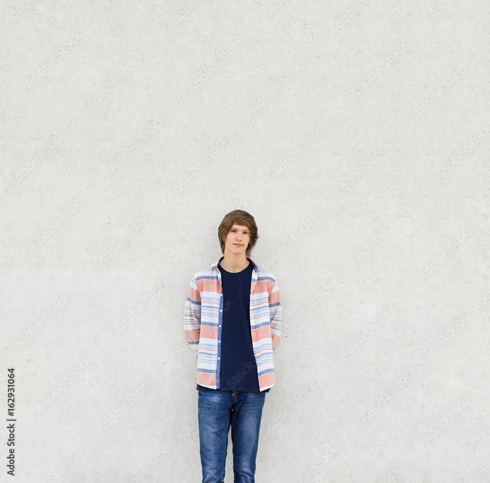 Young boy with trendy haircut wearing shirt and jeans standing near ...