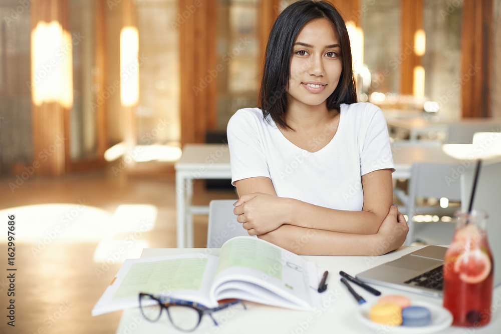 Confident asian student working in library or coworking space getting ...