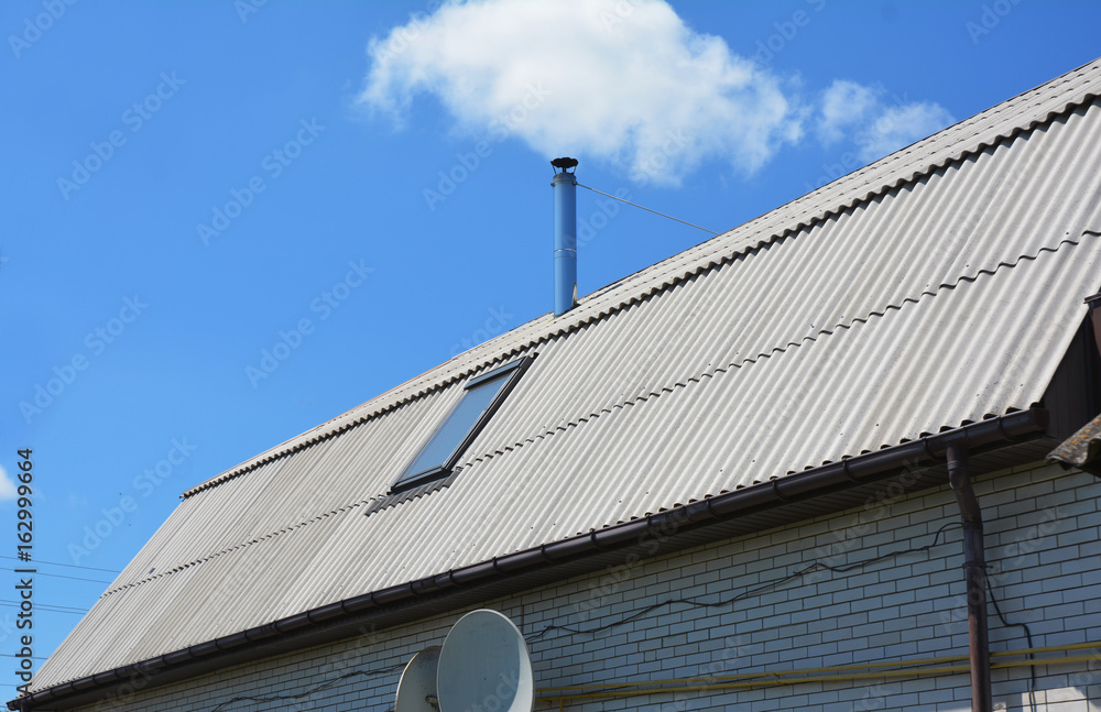 Attic skylight roof window on the asbestos house roof with blue sky ...
