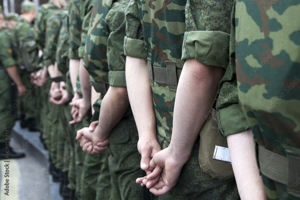 the Back view. Soldiers in camouflage uniforms stand on the ...