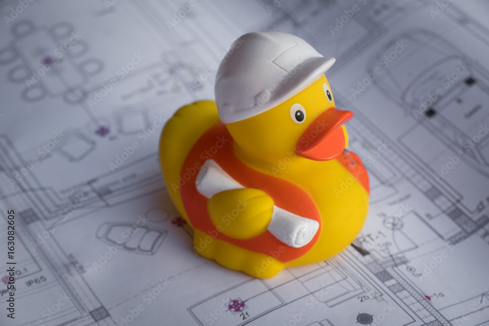 Rubber toy duck construction worker sitting on building plan Stock ...