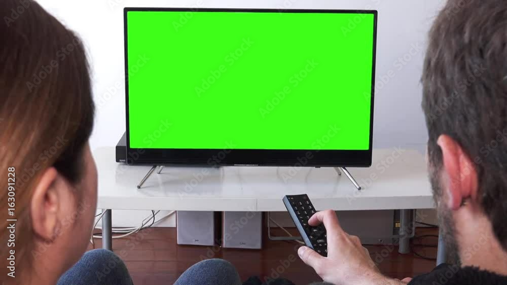 Man Using Television Remote Control With Wife At Side, Panning Shot ...