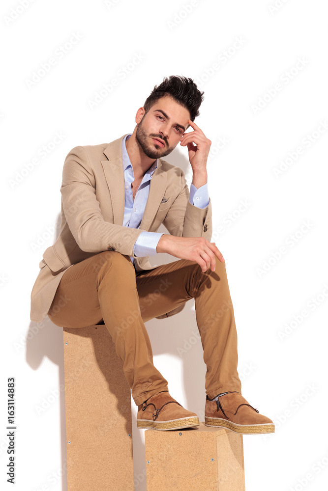 thoughtful young business man sitting on wooden boxes Stock Photo ...