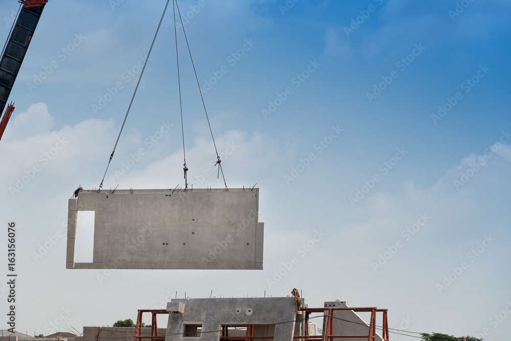 Construction site crane is lifting a precast concrete wall panel. Stock ...