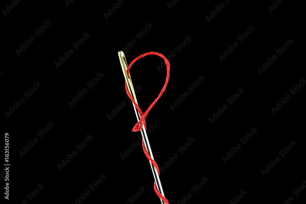 isolated black background with cripping path of one stainless steel needle sewing gold head and ...