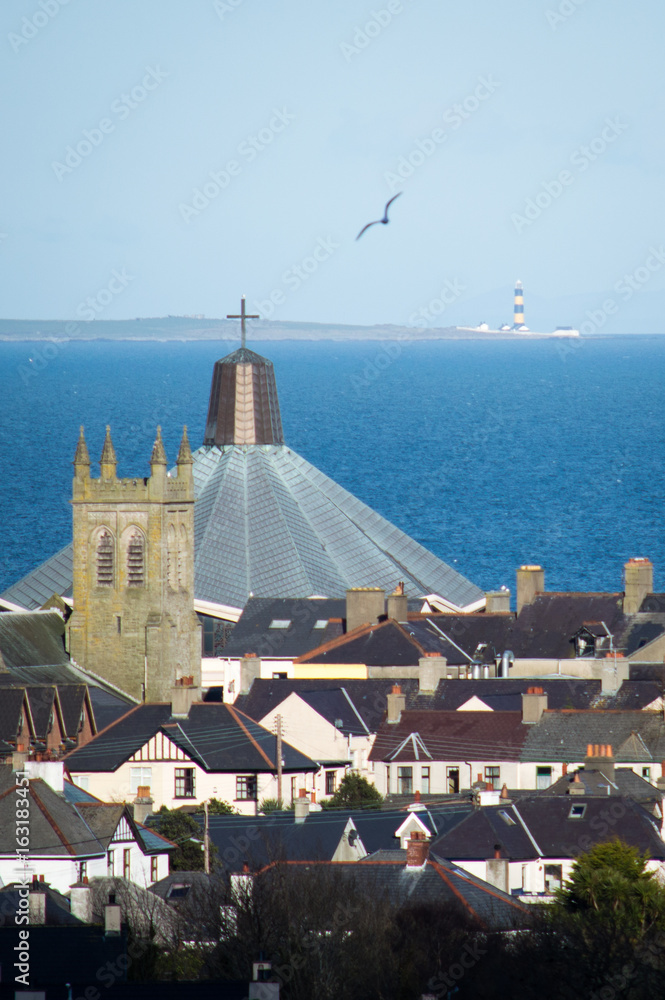 Religious buildings in a town with a lighthouse in the distance Stock ...