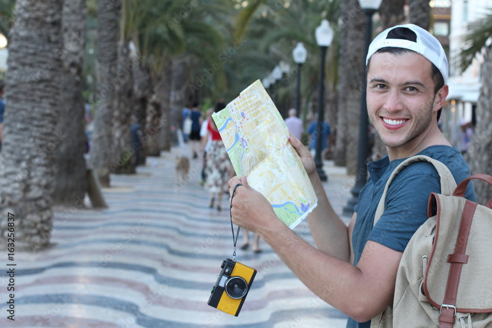 Joyful tourist holding map and camera during a vacation Stock Photo ...