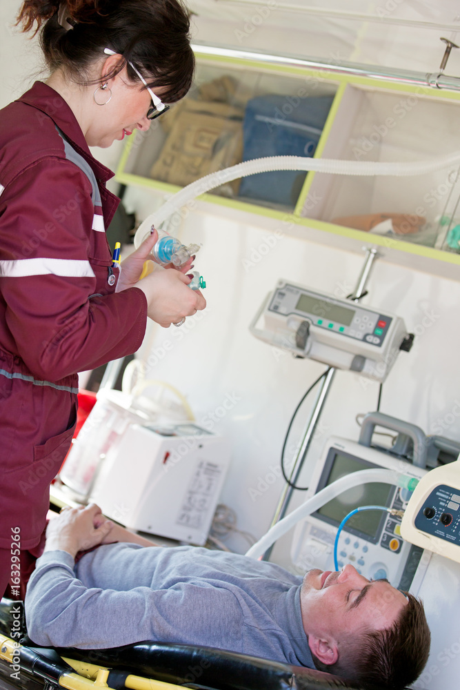Foto de Paramedic preparing oxygen mask to help unconscious man on ...