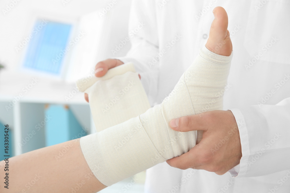 Doctor applying bandage onto patient's leg in clinic, closeup Stock ...