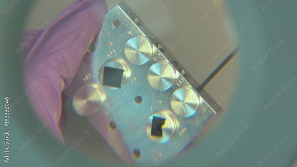 Unscrewing parts of a electron microscope sample table looking through ...