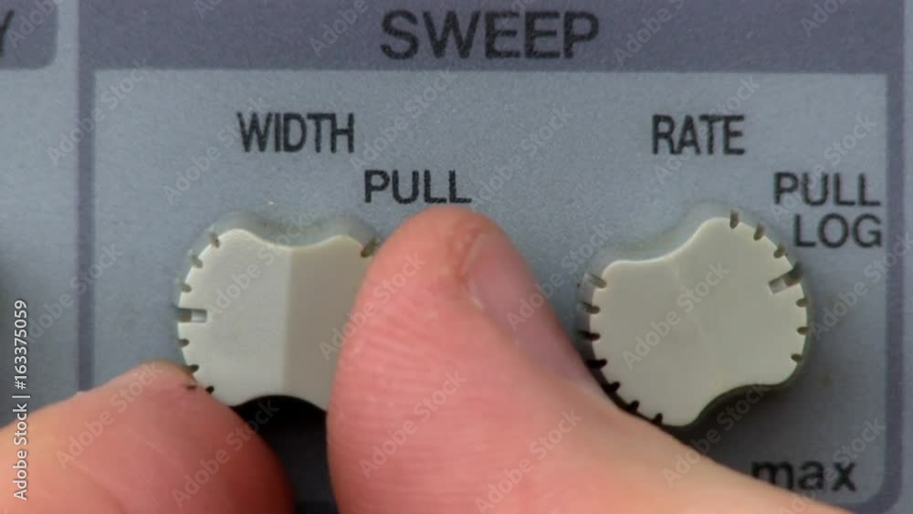 A man turns knobs clockwise and counter clockwise to adjust signal ...