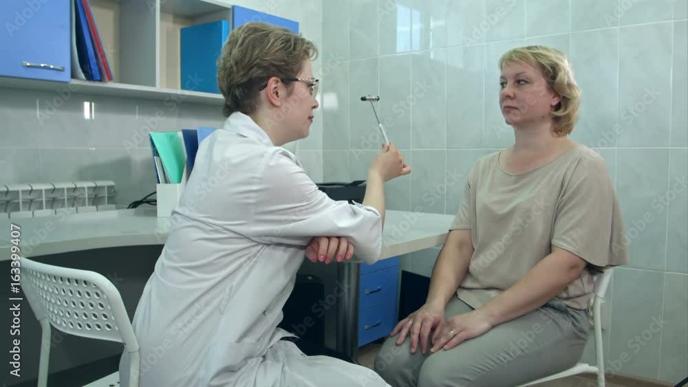 Female neurologist performing neurological tests on a female patient in ...