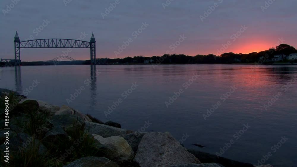 Train bridge over tranquil waters of Cape Cod Canal frames distant ...