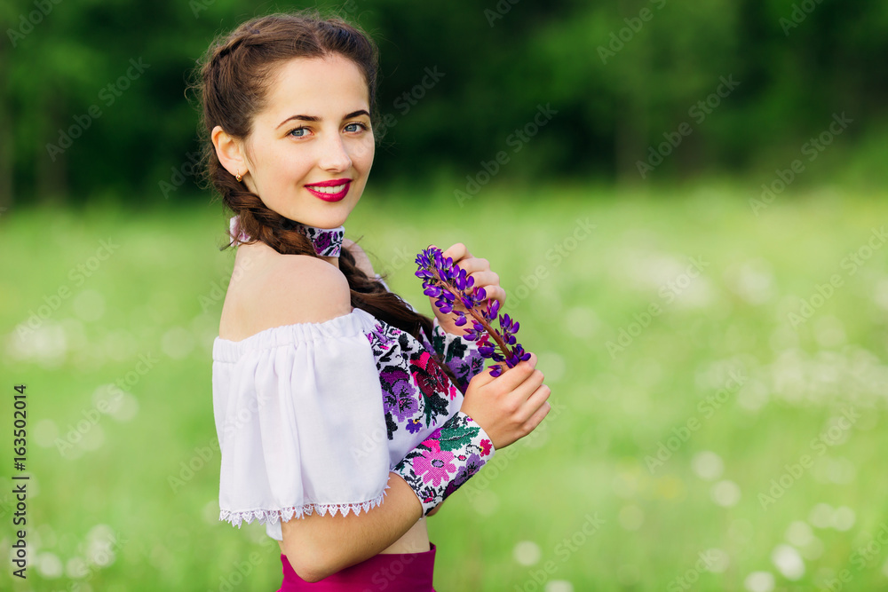 Pretty Ukrainian Girl With Naked Shoulder Smiling And Holding Lupine