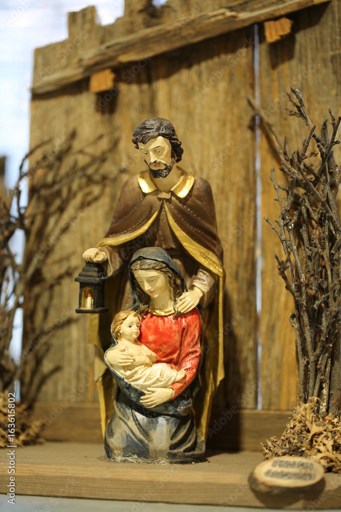 nativity scene with the Holy Family and Saint joseph who holds a Stock ...