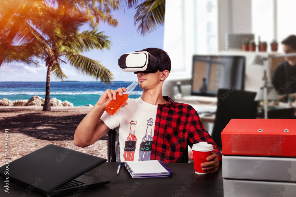 Young businessman visualizing a beach vacation using a VR headset sits ...