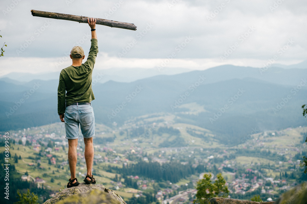 Strong man with wooden staff stick looking far at horizon. Primal ...