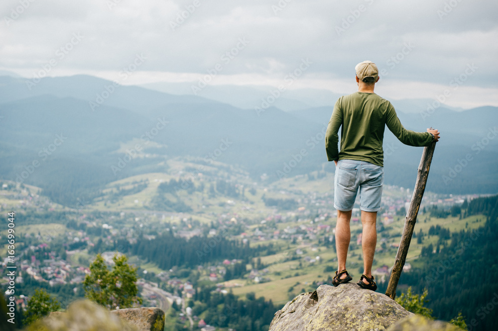 Strong man with wooden staff stick looking far at horizon. Primal ...