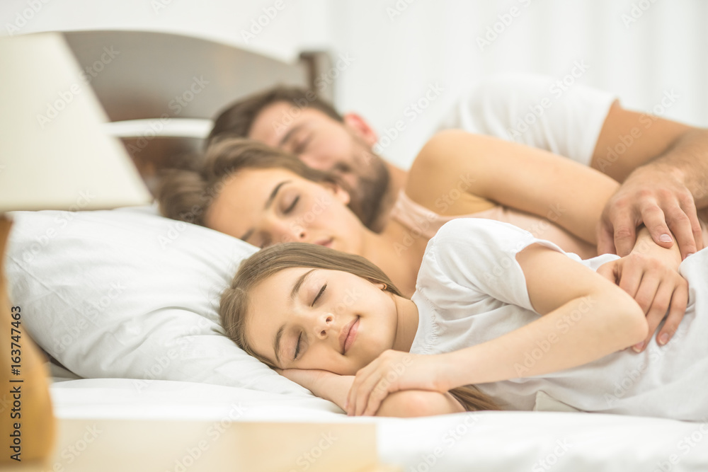 The daughter and parents sleeping in the comfortable bed Stock Photo ...