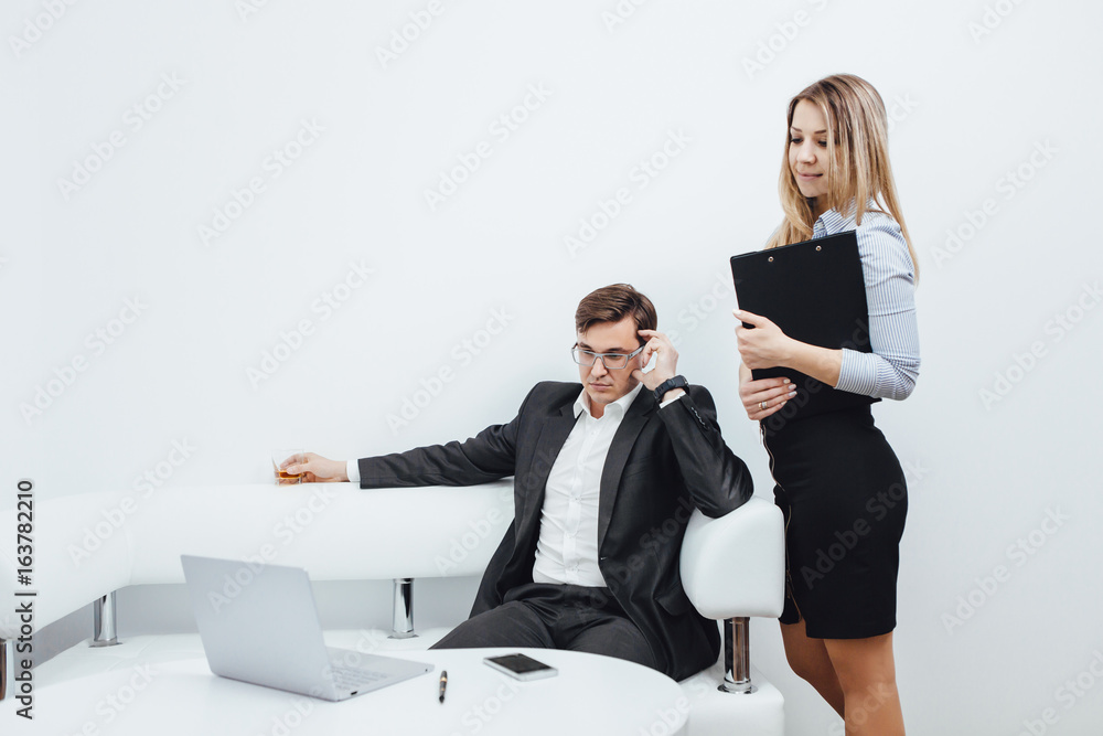 Elegant secretary bringing some documents for signature to her boss ...