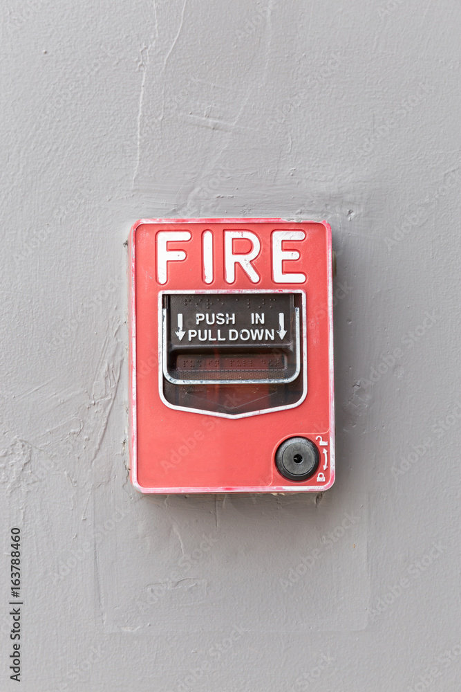 Red fire alarm switch on exterior cement wall of commercial building ...