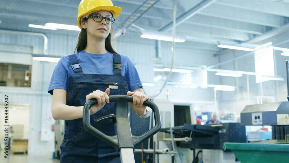 Beautiful Female Worker in Hard Hat Operates Pallet Lifter in a Big ...
