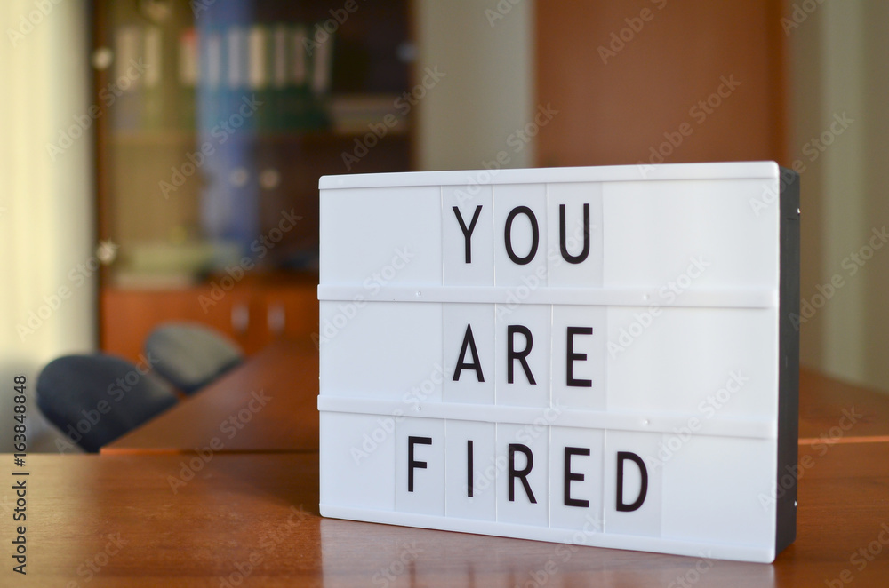 You are fired sign in lightbox put on the desk in office interior ...