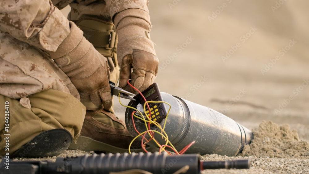 Close-up shot of Soldier Defusing a Bomb by Cutting a Wire During ...