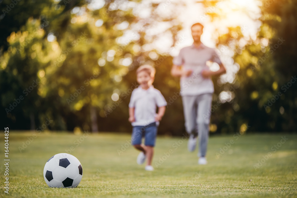 Dad with son playing football Stock Photo | Adobe Stock