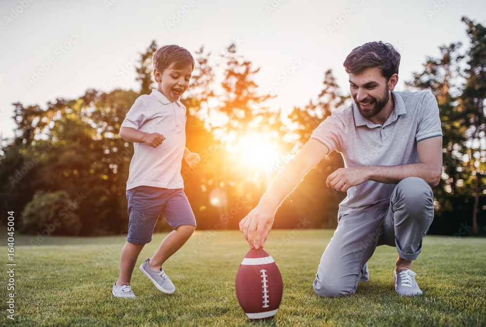 Dad with son playing American football Stock Photo | Adobe Stock