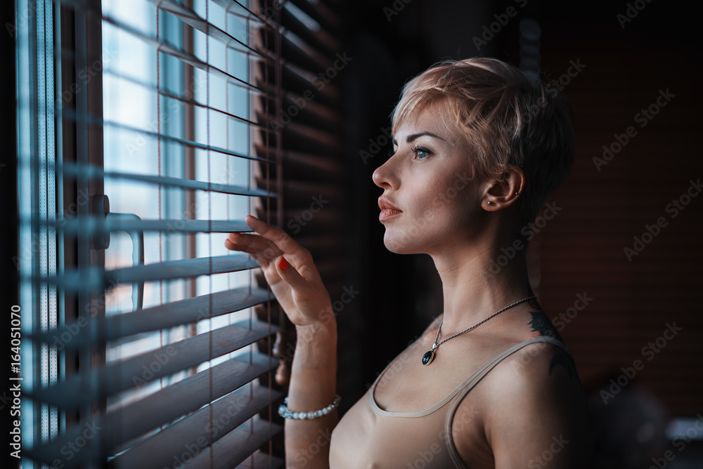girl at the window with jalousie/ beautiful girl at the window of the ...