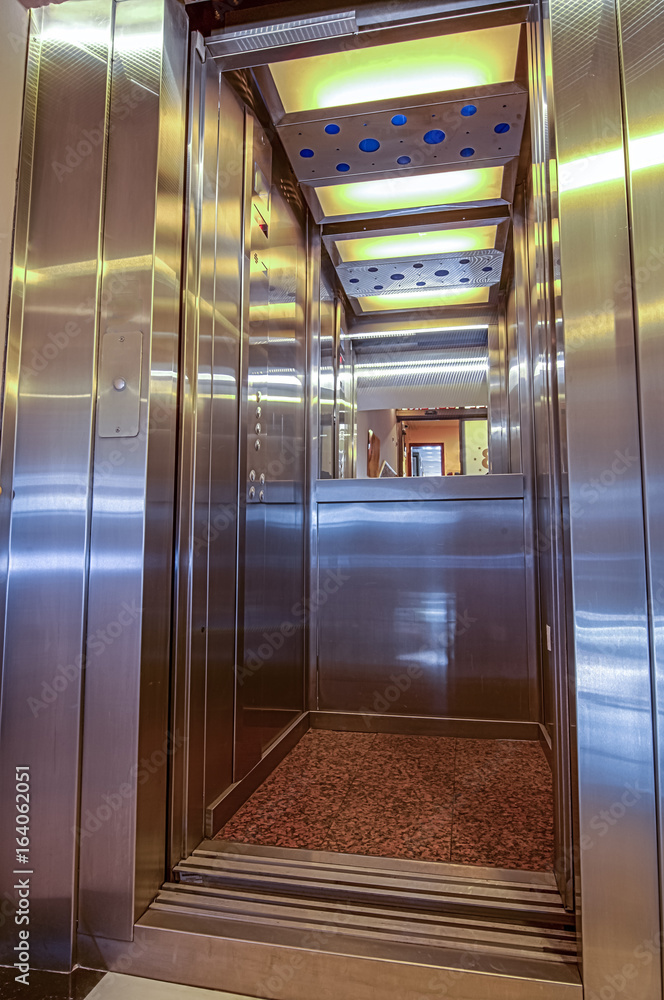 Elevator with new and modern cabin made of bright alloy and metal with ...