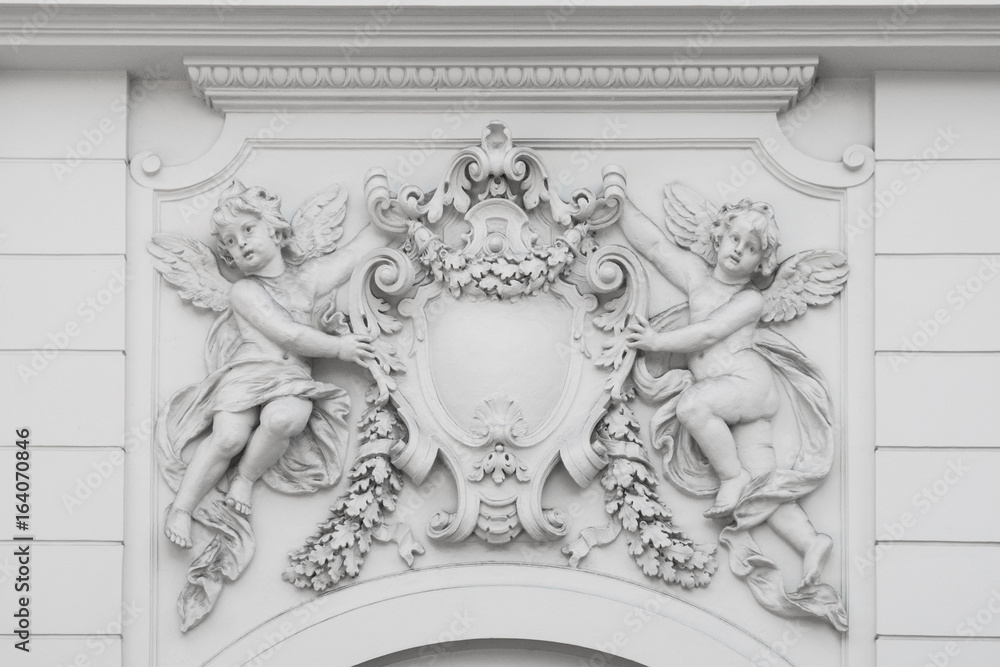 angel statues holding emblem - sculptures on house facade Stock Photo ...