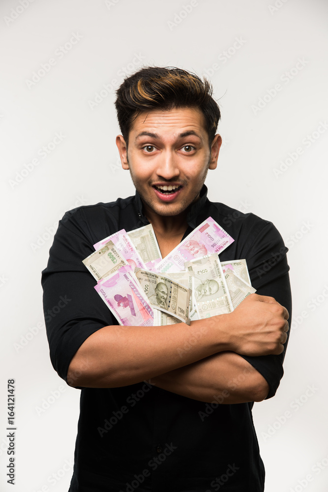 Happy Indian young man holding new indian currency or 2000 or 500 rupee ...