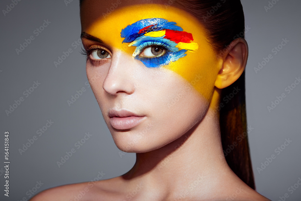 Fashion model woman with colored face painted. Beauty fashion art ...