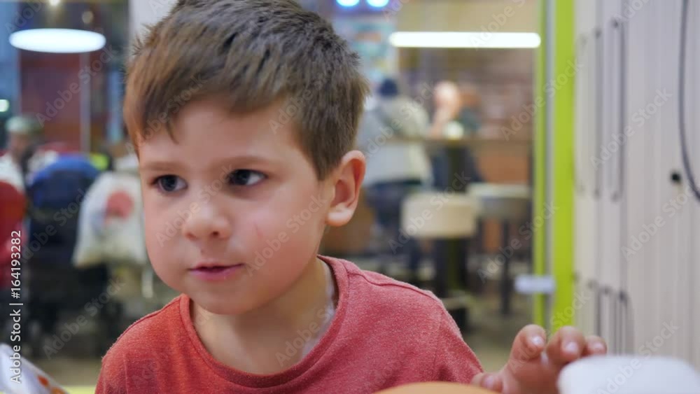 Vídeo do Stock: Kid plays with harmful food at table, Hamburger and ...