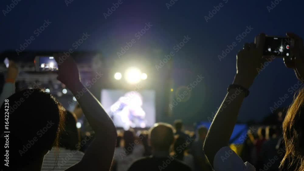 fans records concert on cellphones, on background flag Ukraine ...