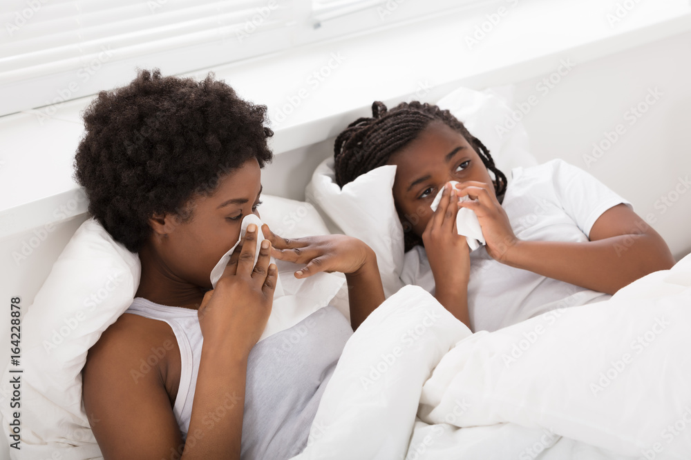 Mother And Daughter Sneezing In Tissues Stock Photo | Adobe Stock