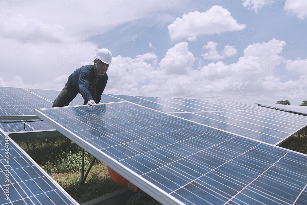engineer or electrician working on replacement solar panel at solar ...